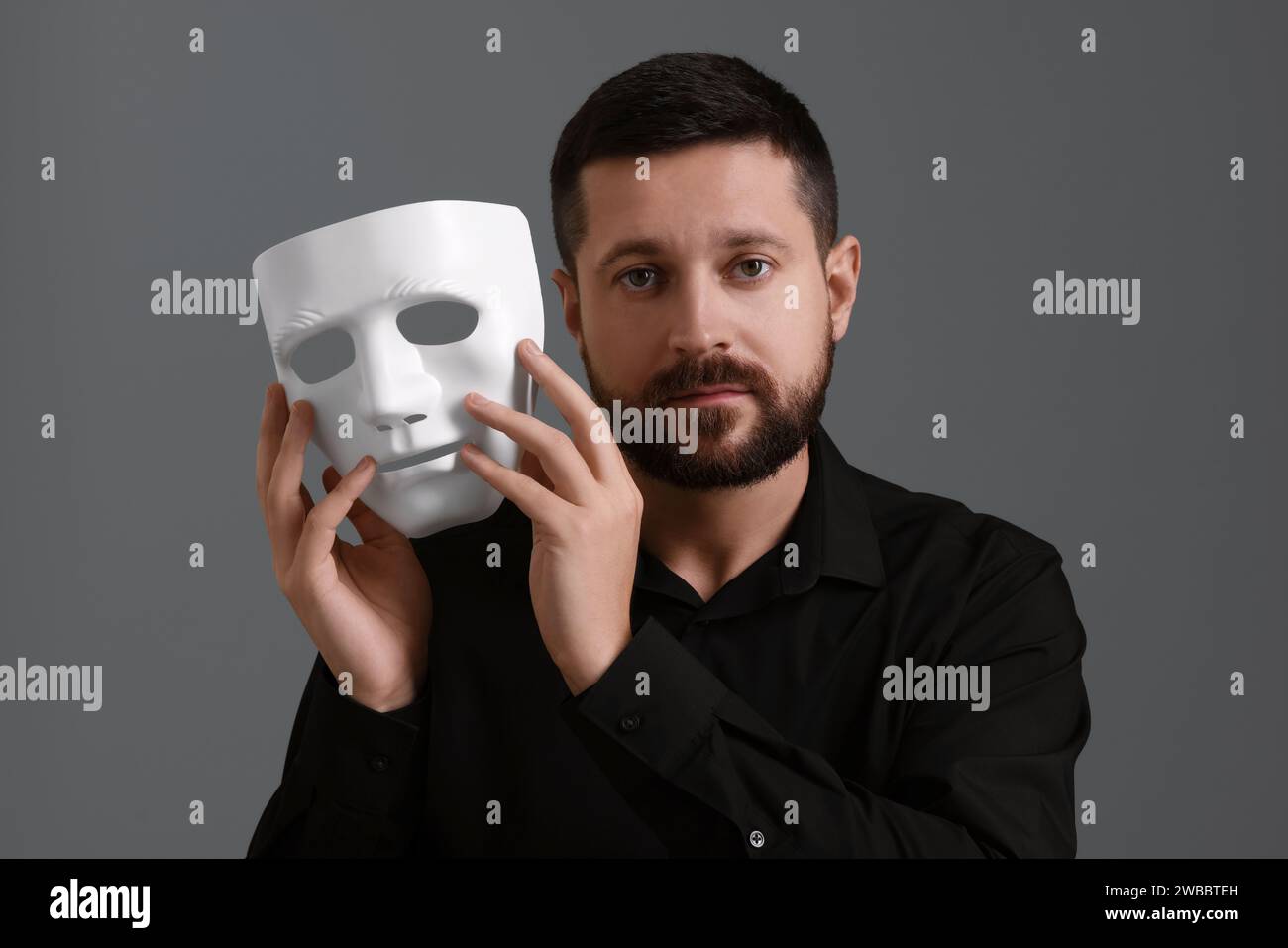 Multiple personality concept. Man with mask on grey background Stock ...