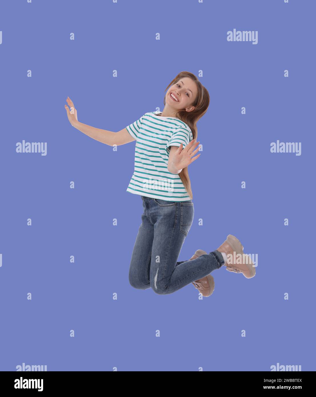 Happy cute girl jumping on light blue background Stock Photo - Alamy