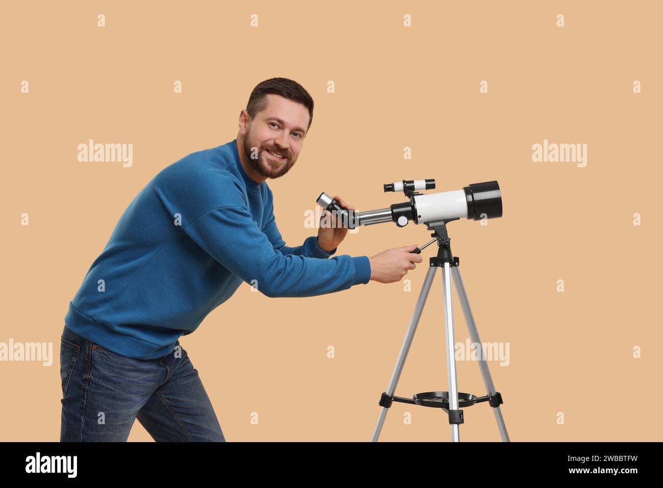 Happy astronomer with telescope on beige background Stock Photo - Alamy