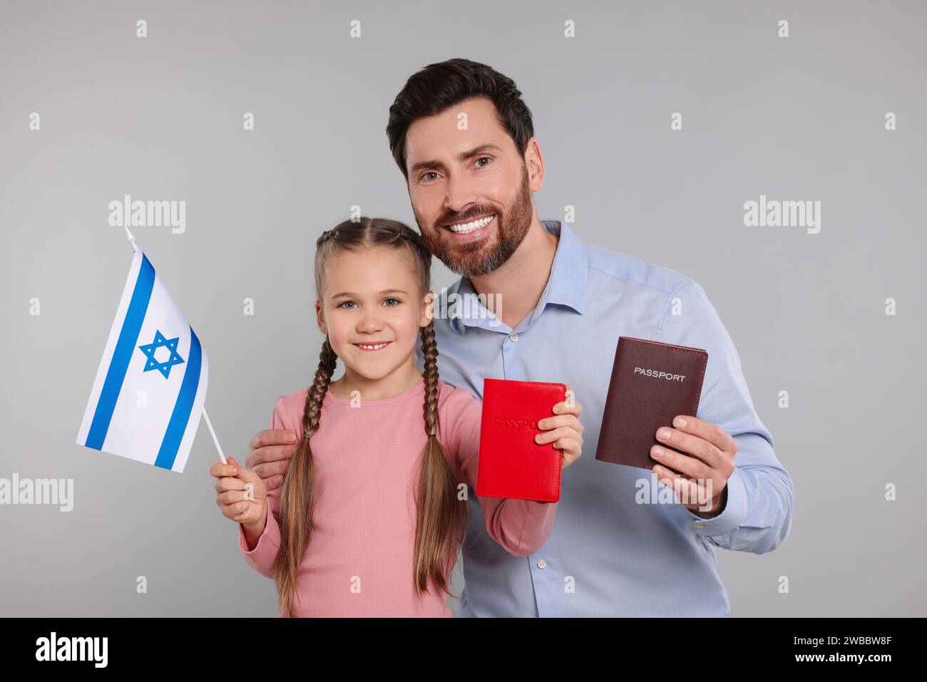 Immigration. Happy man with his daughter holding passports and flag of ...