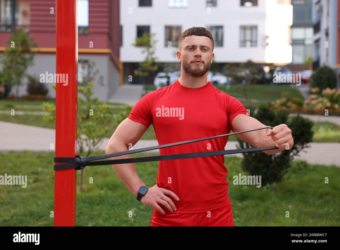 Muscular man doing exercise with elastic resistance band outdoors Stock ...