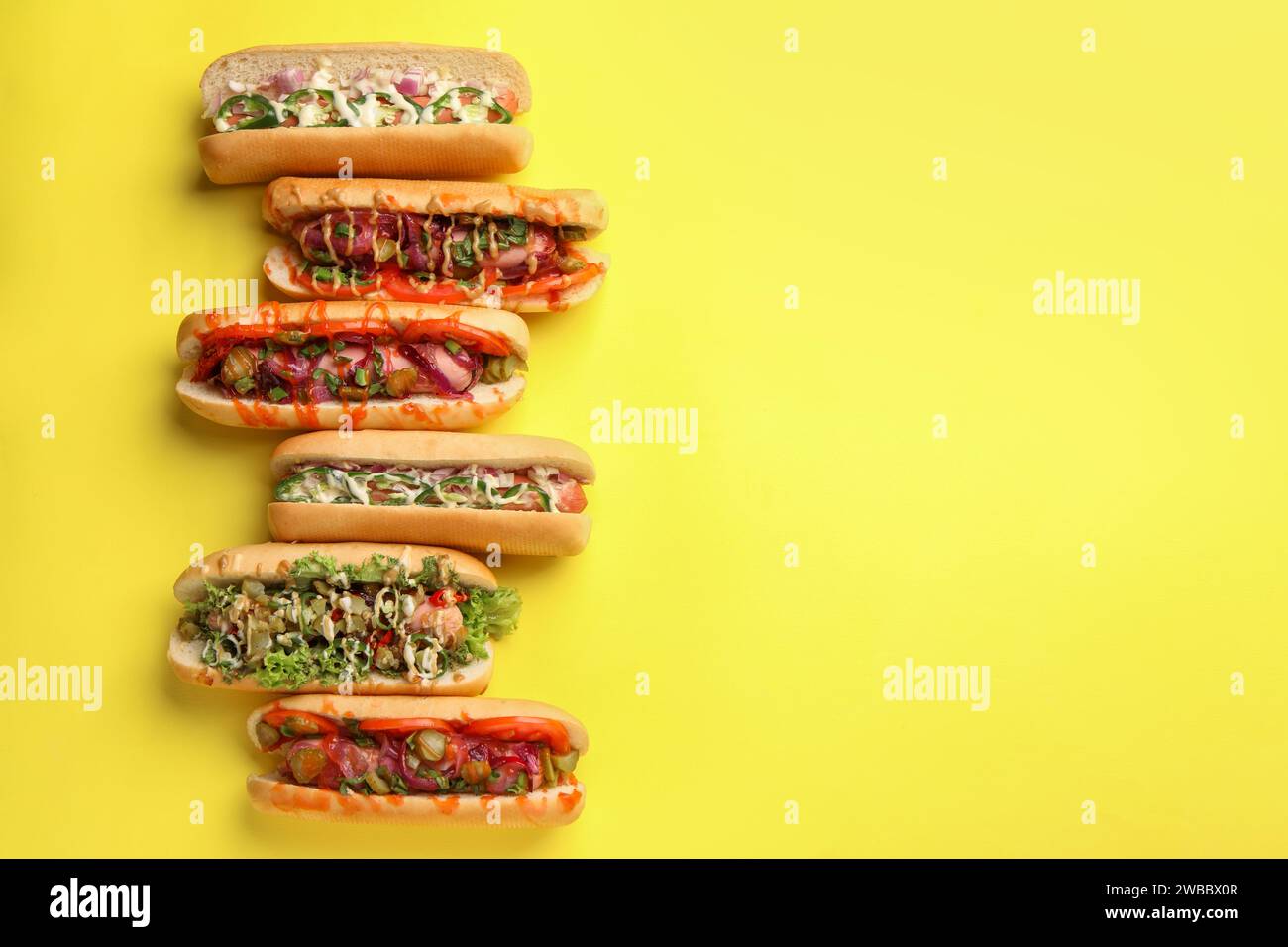 Delicious hot dogs with different toppings on yellow background, flat ...