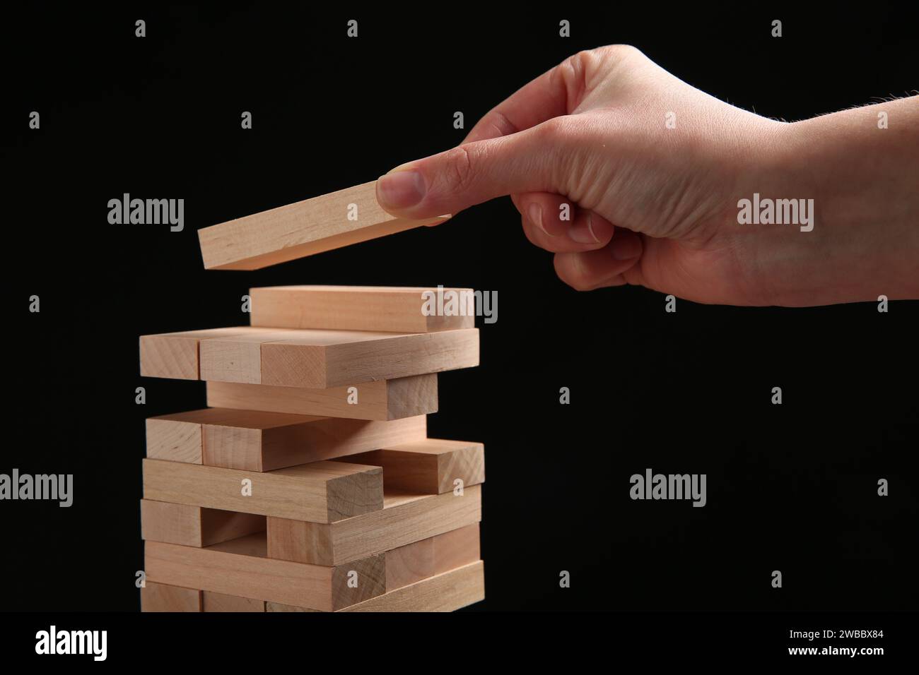 Woman playing Jenga on black background, closeup Stock Photo - Alamy