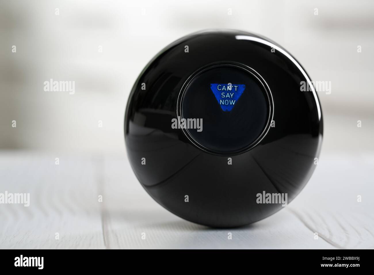 Magic eight ball with prediction Can't Say Now on light table, closeup ...