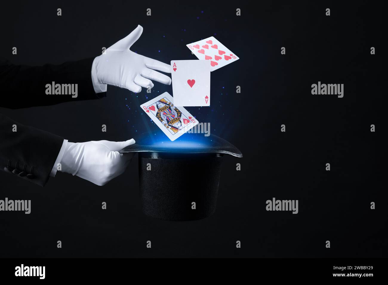 Magician showing trick with cards and top hat on black background ...