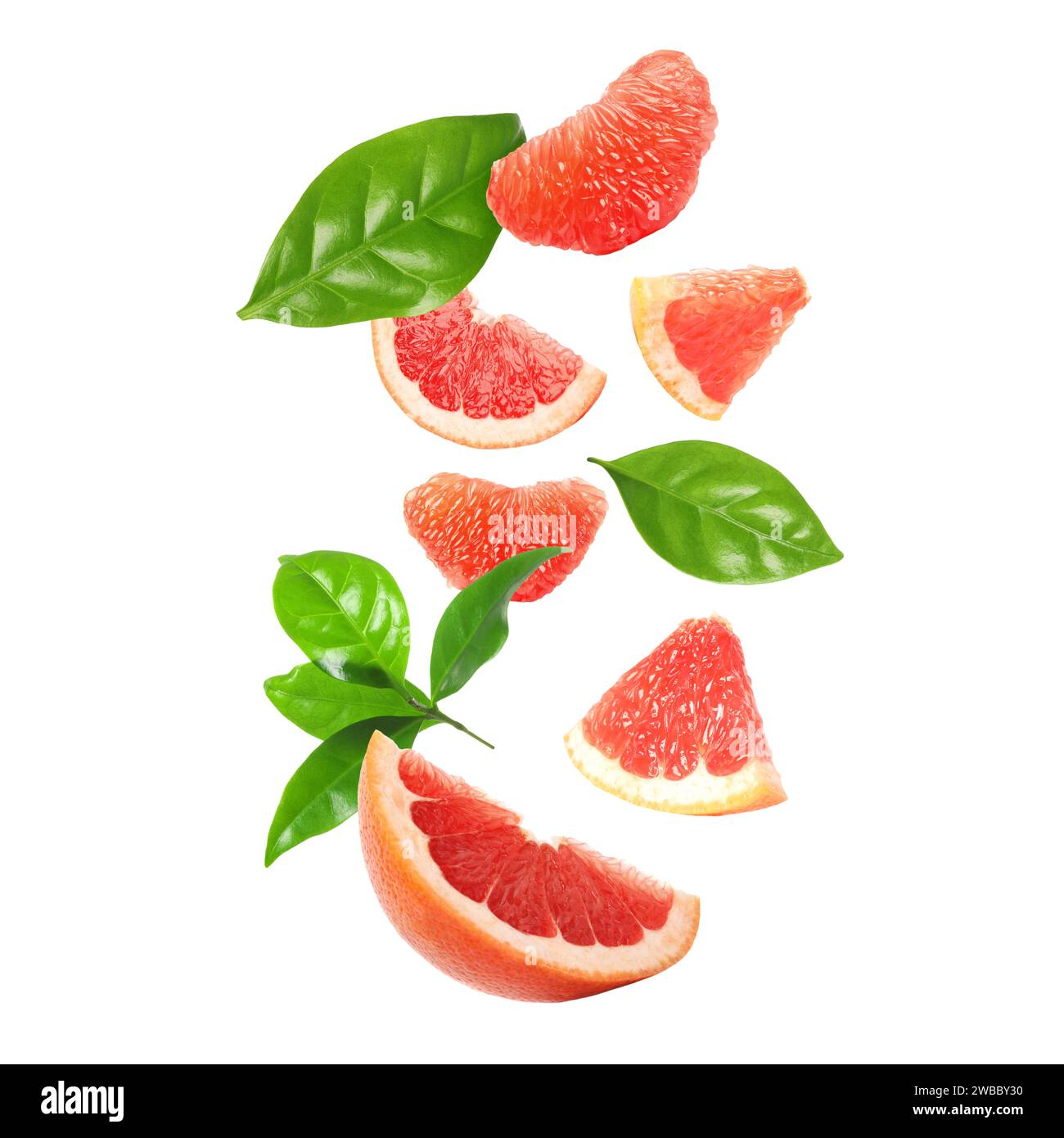 Fresh grapefruit pieces and green leaves falling on white background ...