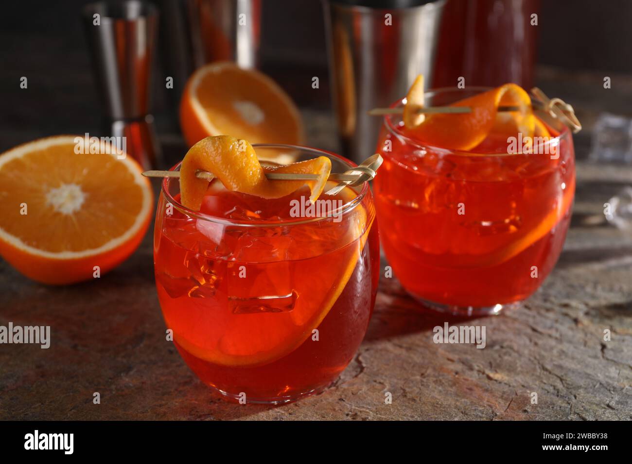 Aperol spritz cocktail, ice cubes and orange slices in glasses on grey ...