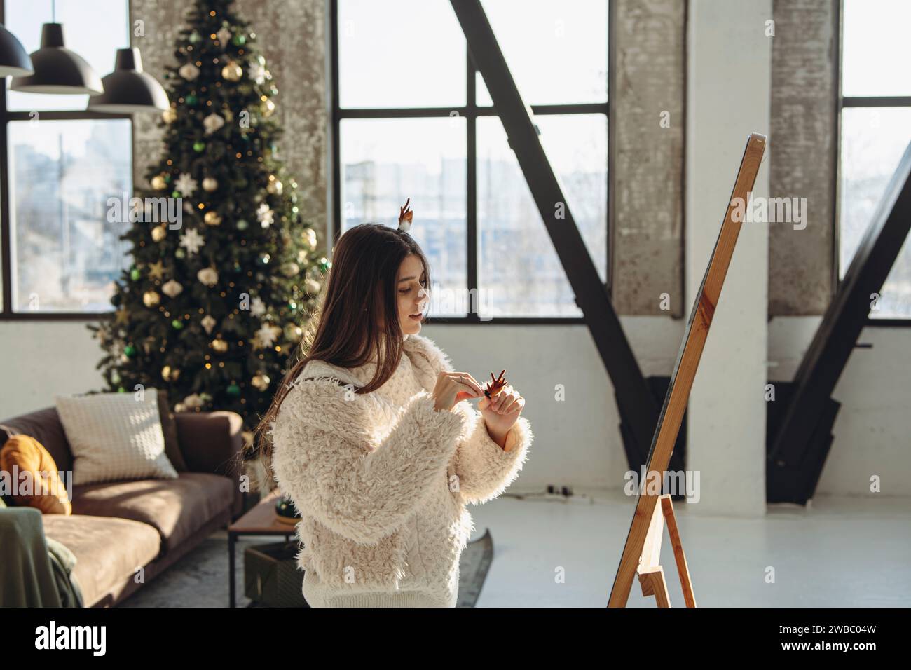 Radiating happiness, a vibrant young lady wearing a Christmas reindeer ...