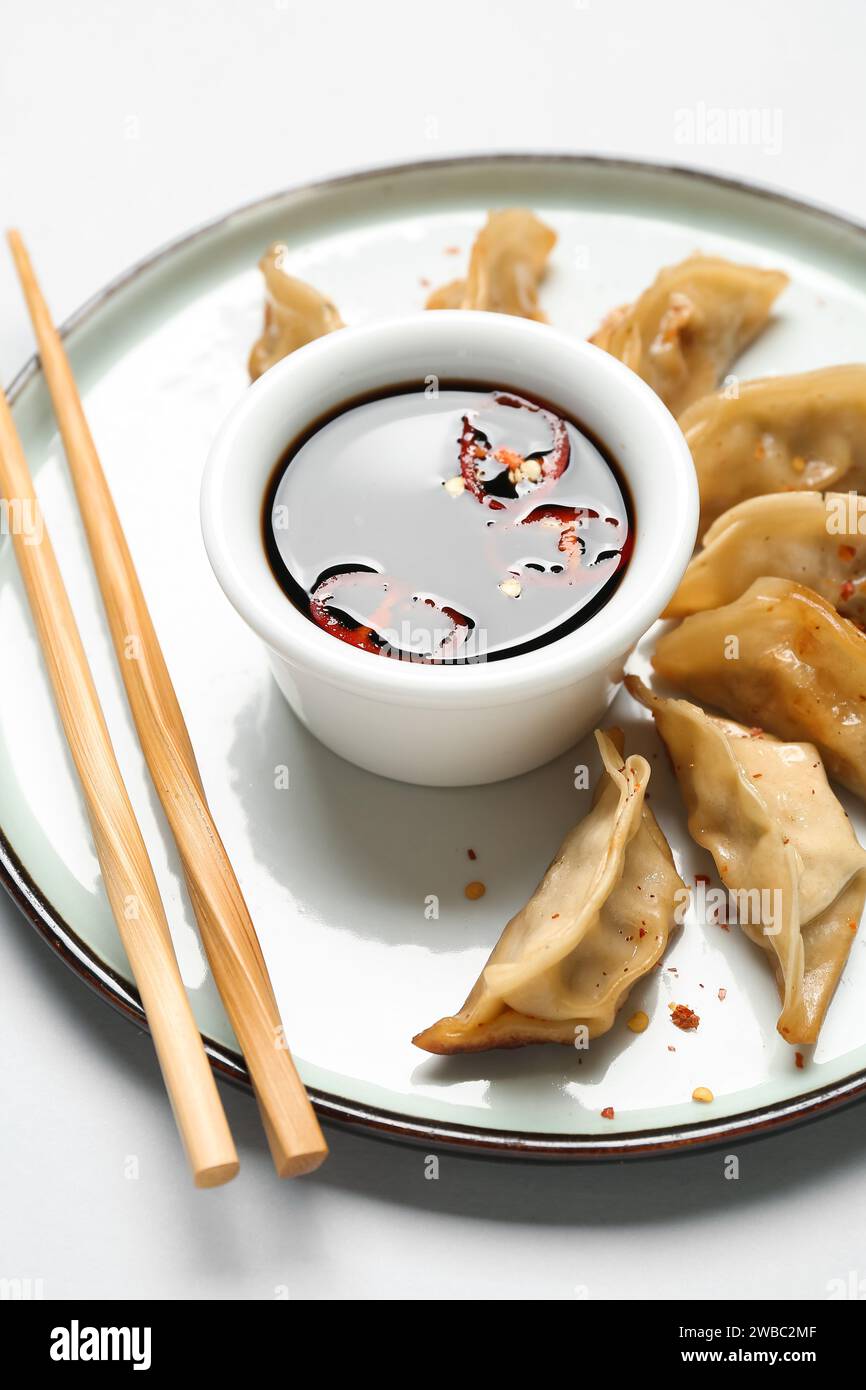 Plate with bowl of sauce and tasty Chinese jiaozi on white background Stock Photo - Alamy