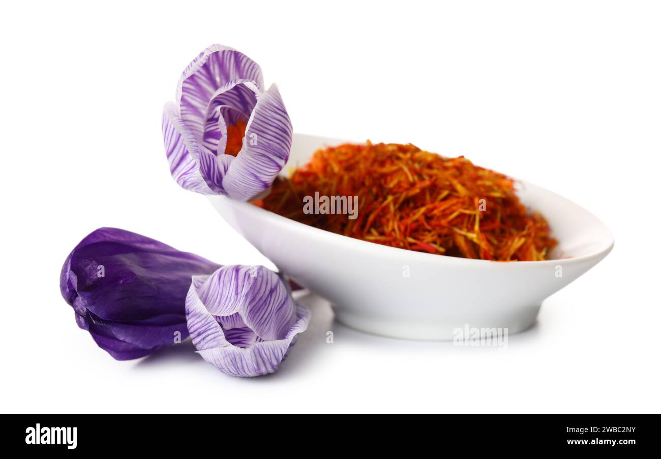 Bowl of dried saffron threads and crocus flowers isolated on white ...