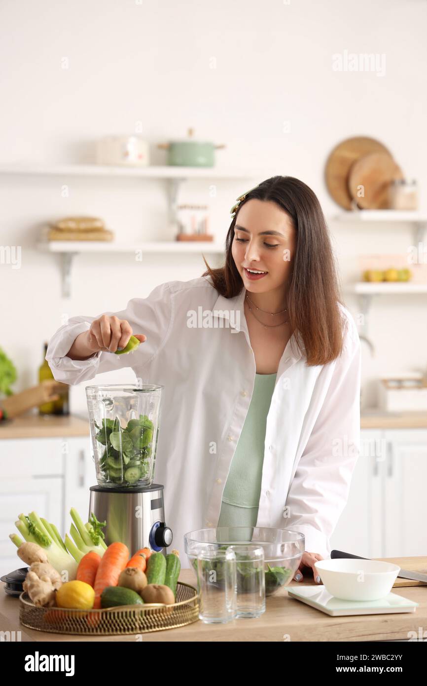 Young woman squeezing lime juice into blender in kitchen Stock Photo ...