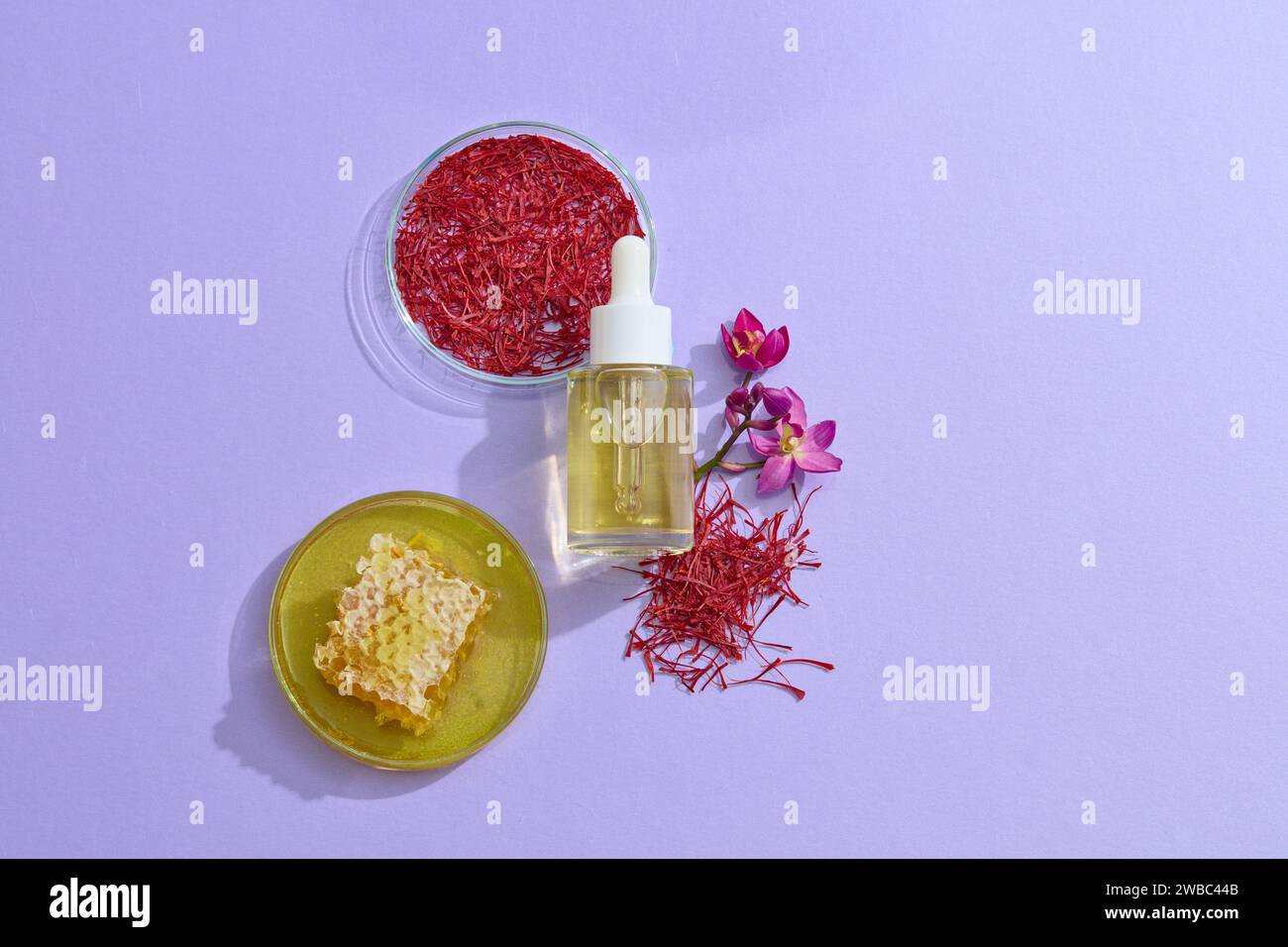 Fresh ingredients saffron and honey displayed on purple background with ...