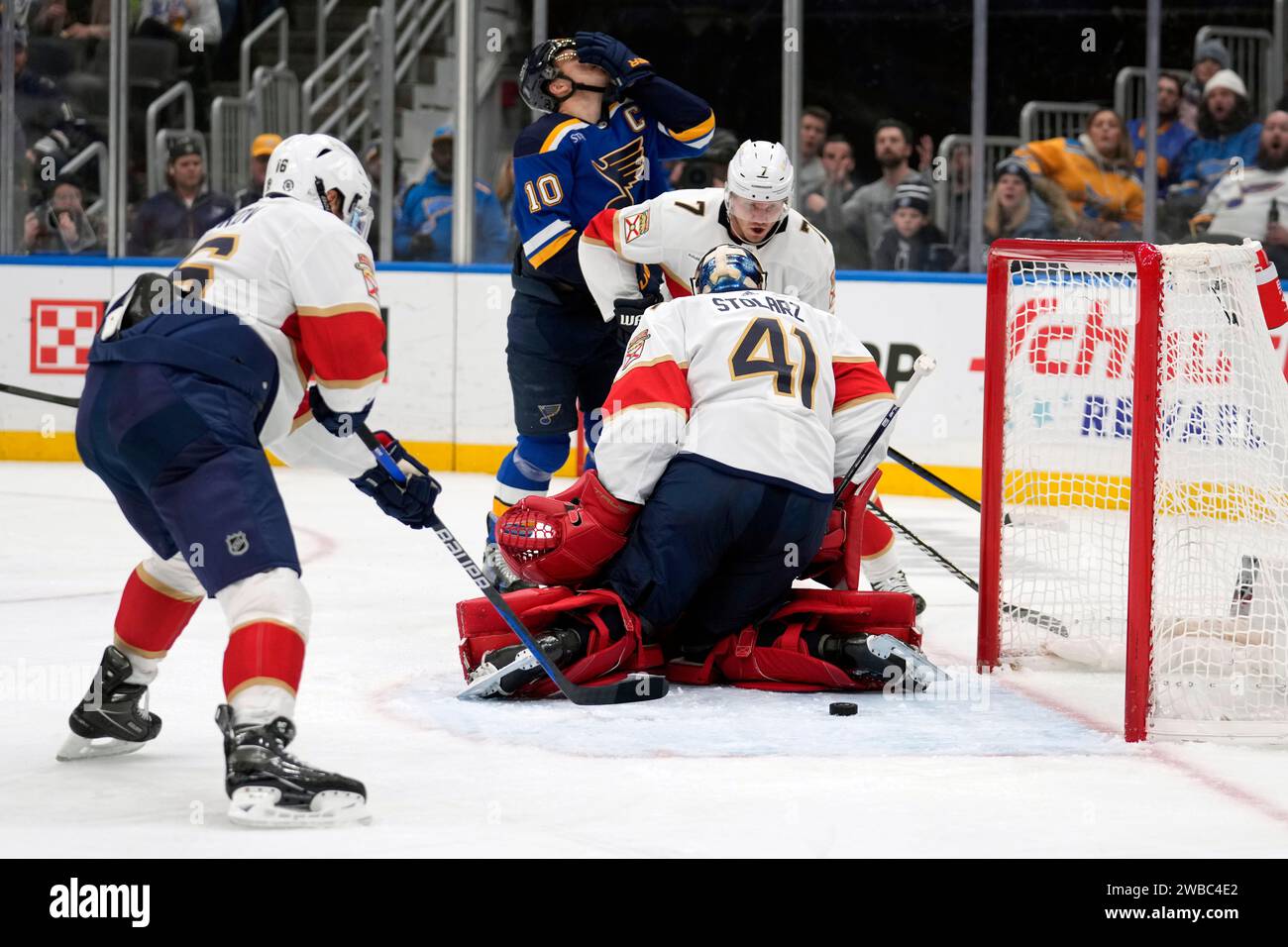 St. Louis Blues' Brayden Schenn (10) holds his face as the puck slips ...
