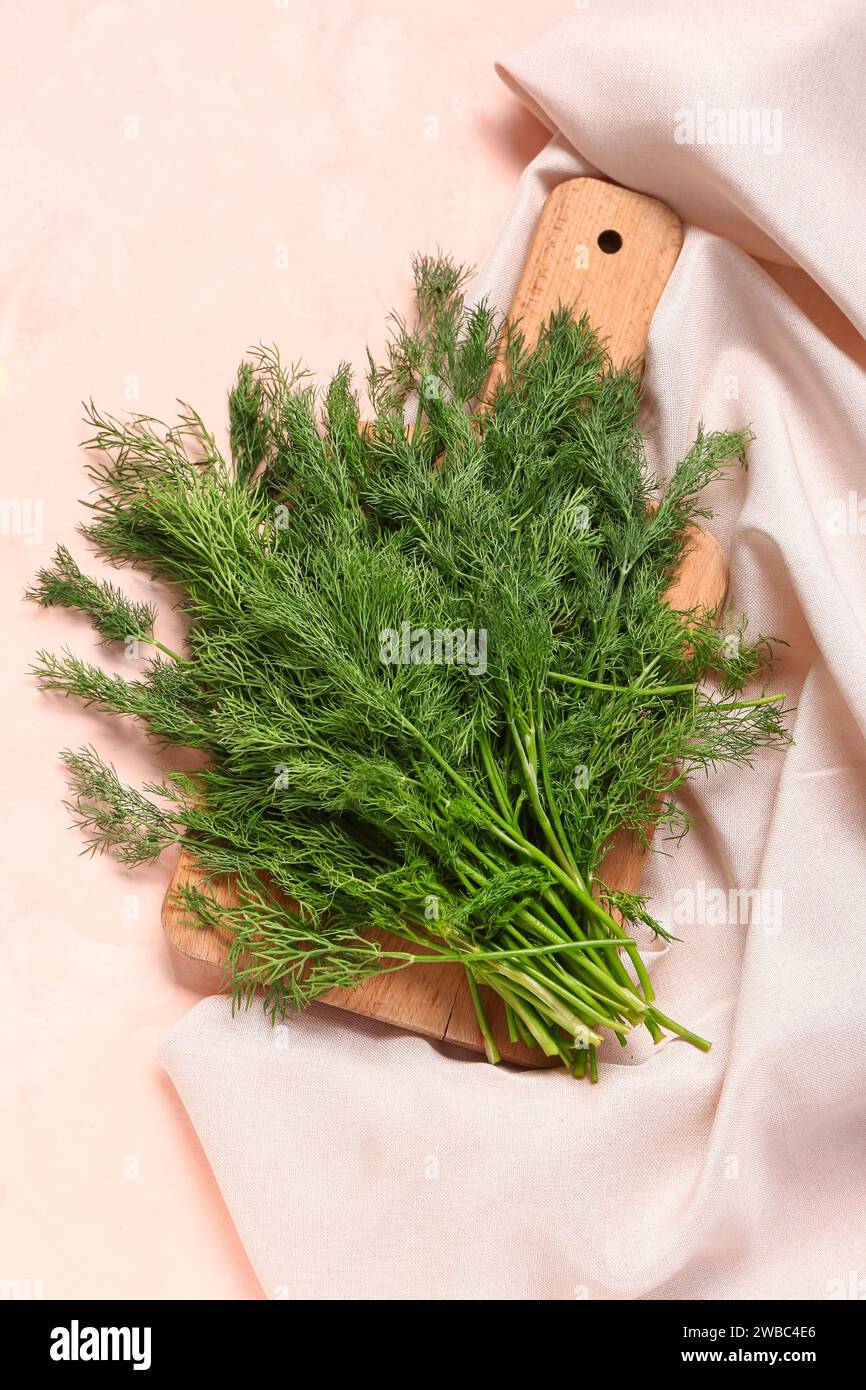 Wooden board with fresh dill on pink background Stock Photo - Alamy