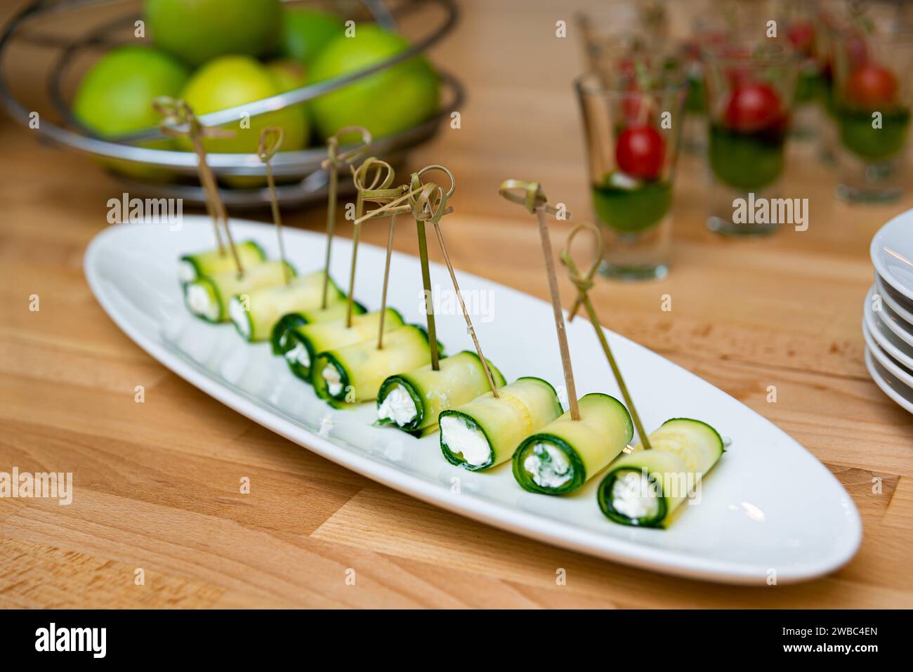 Delicate cucumber rolls filled with cream cheese presented on a white ...