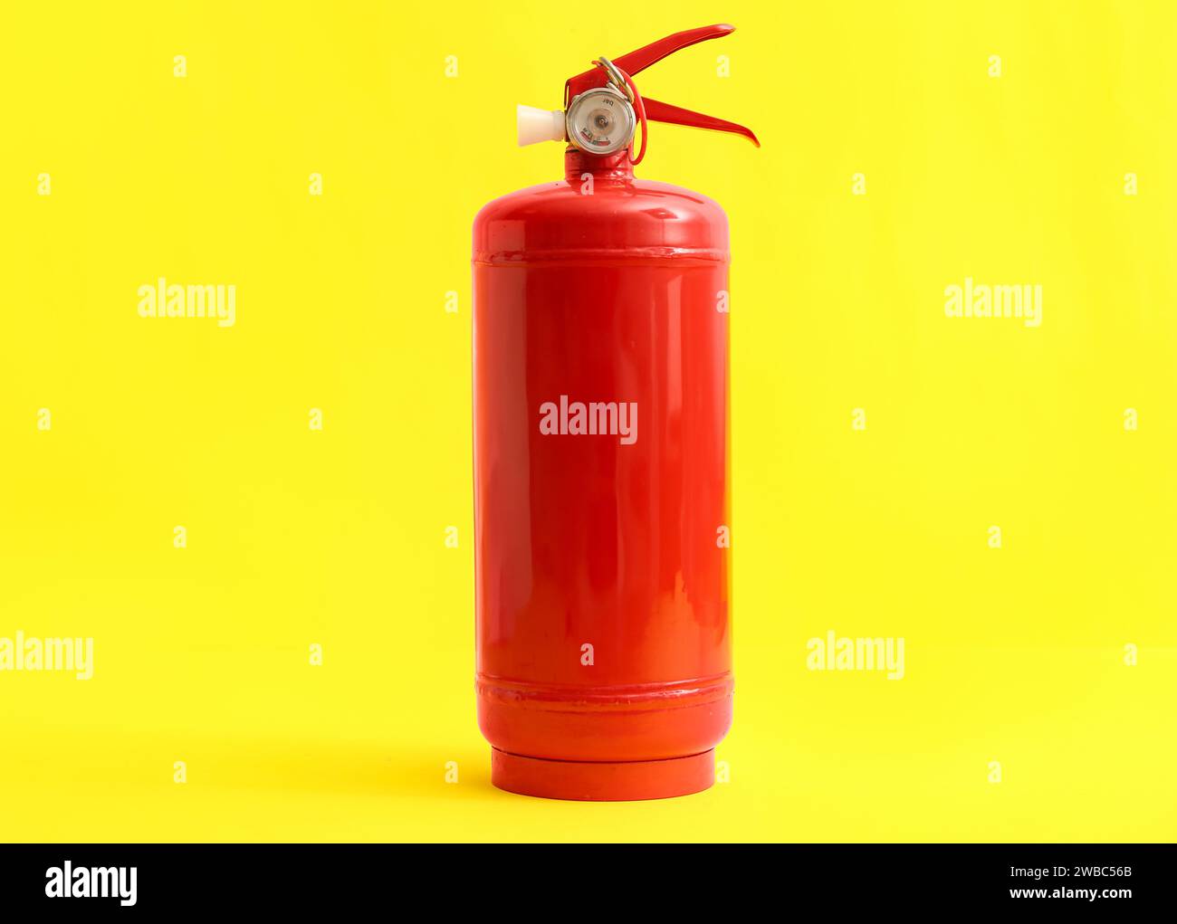 Fire extinguisher on yellow background Stock Photo - Alamy