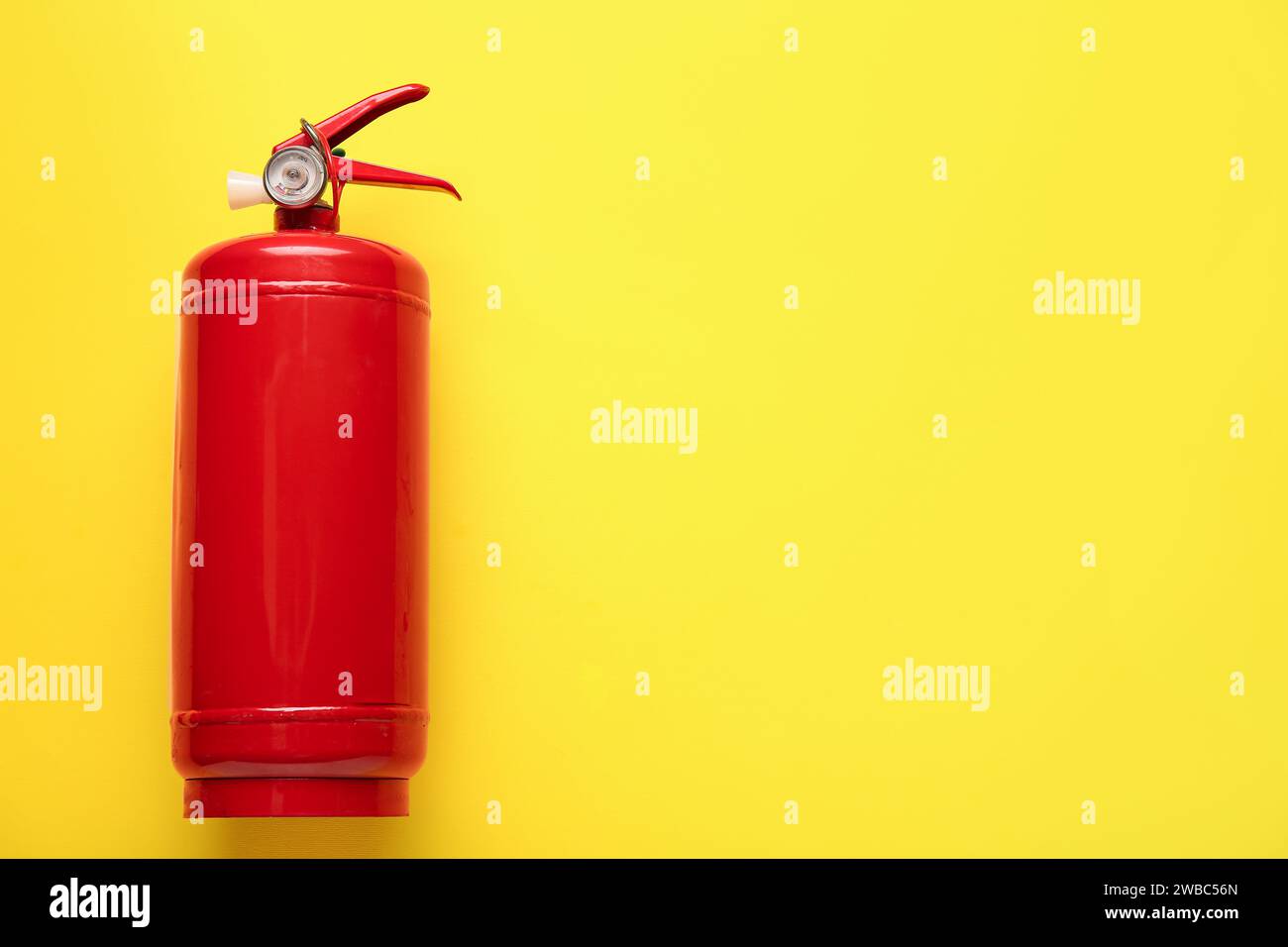 Fire extinguisher on yellow background Stock Photo - Alamy