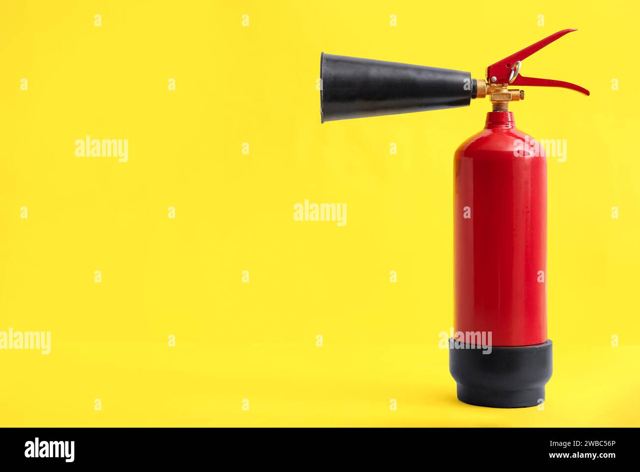 Fire extinguisher on yellow background Stock Photo - Alamy