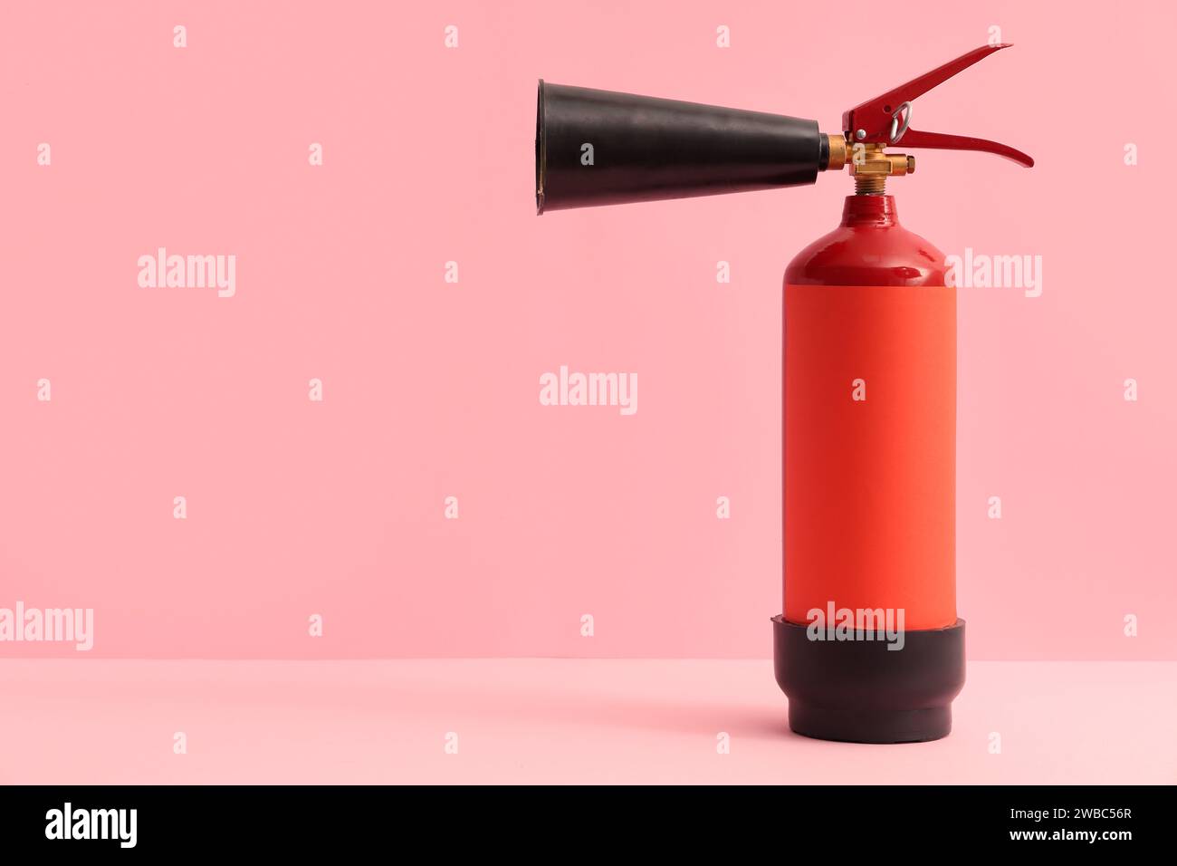 Fire extinguisher on pink background Stock Photo - Alamy