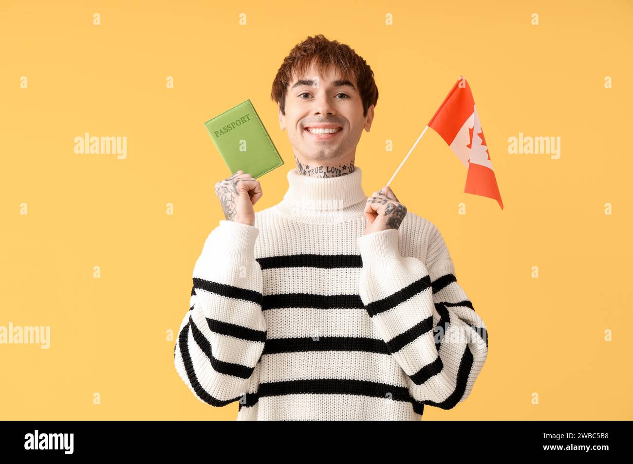 Handsome young man with flag of Canada and passport on yellow ...