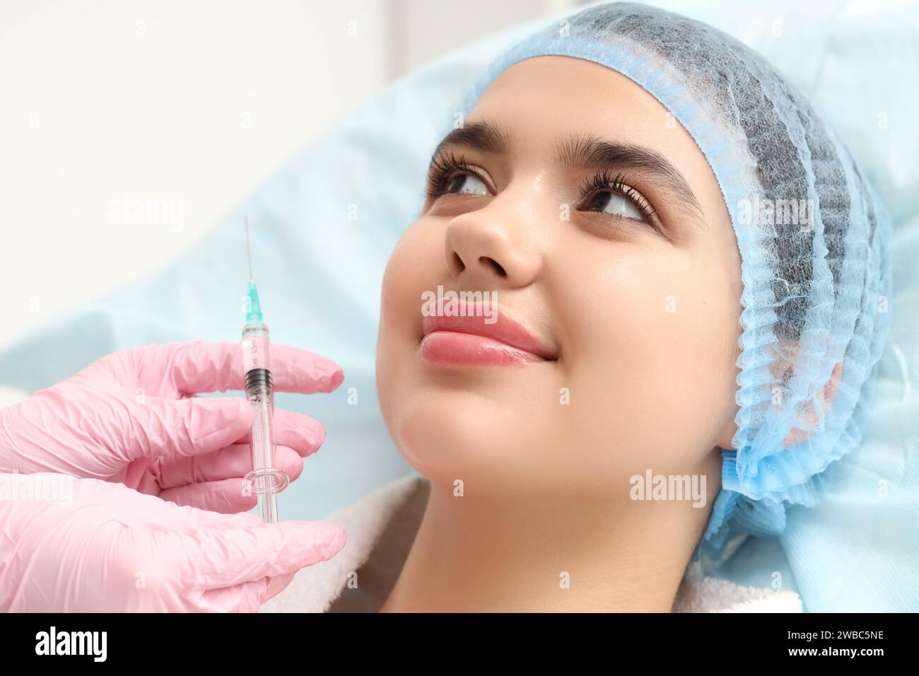 Cosmetologist giving injection to young woman in beauty salon, closeup ...