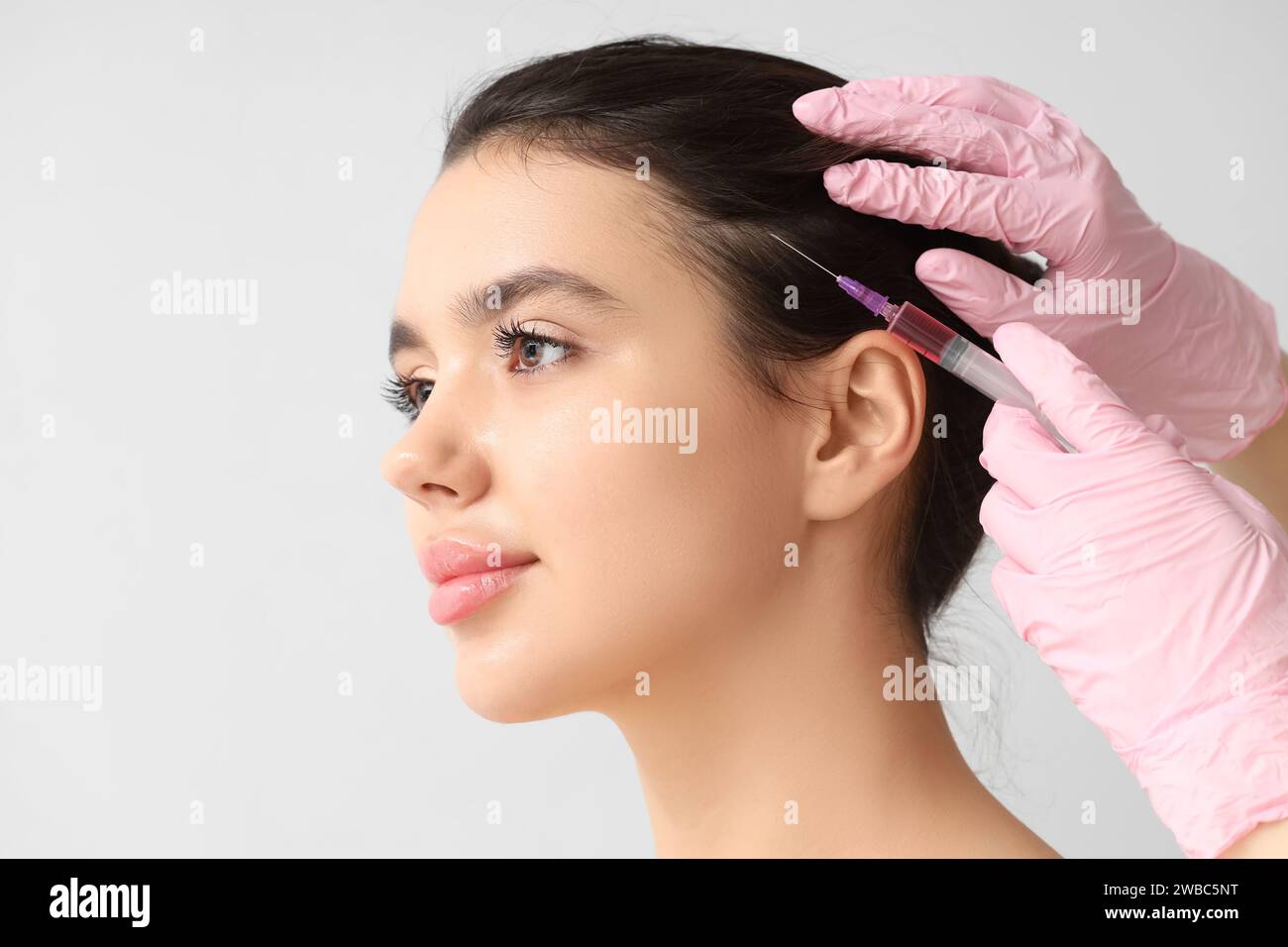 Young woman receiving hair injection on light background, closeup Stock ...