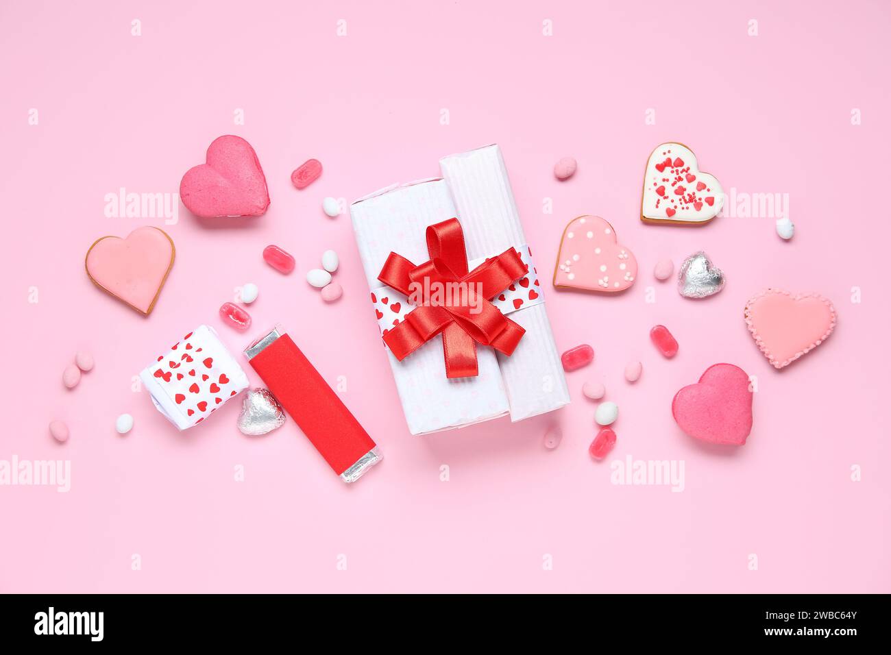 Heart-shaped cookies with different sweets and gift boxes on pink ...