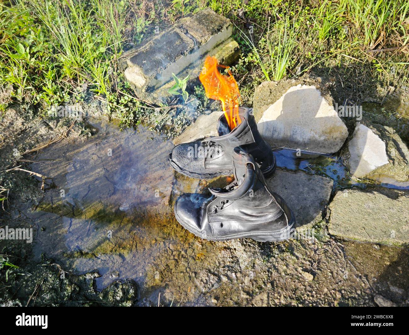 old thrown away leather boot on flame in the farm Stock Photo - Alamy
