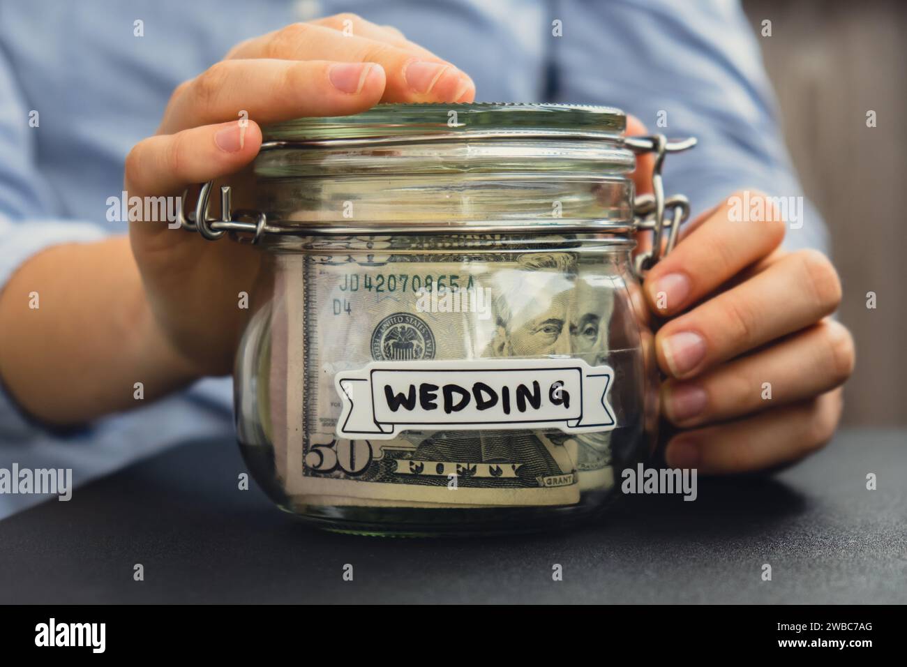 Female hands holding Glass jar full of American currency dollars cash ...