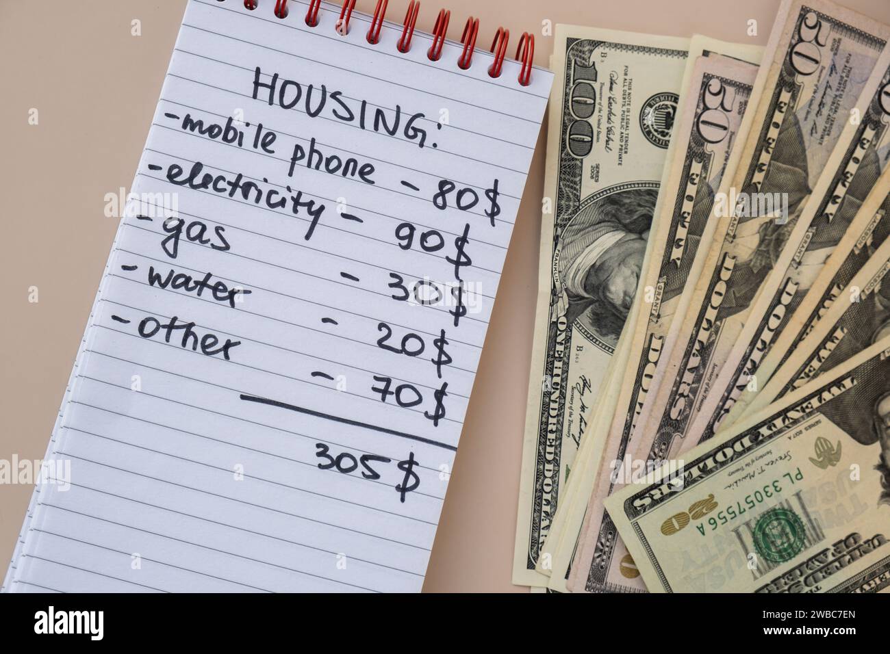 Dollar cash money with notebook handwritten housing expenses. Counting ...