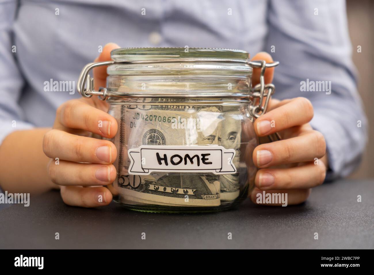 Female hands holding Glass jar full of American currency dollars cash ...