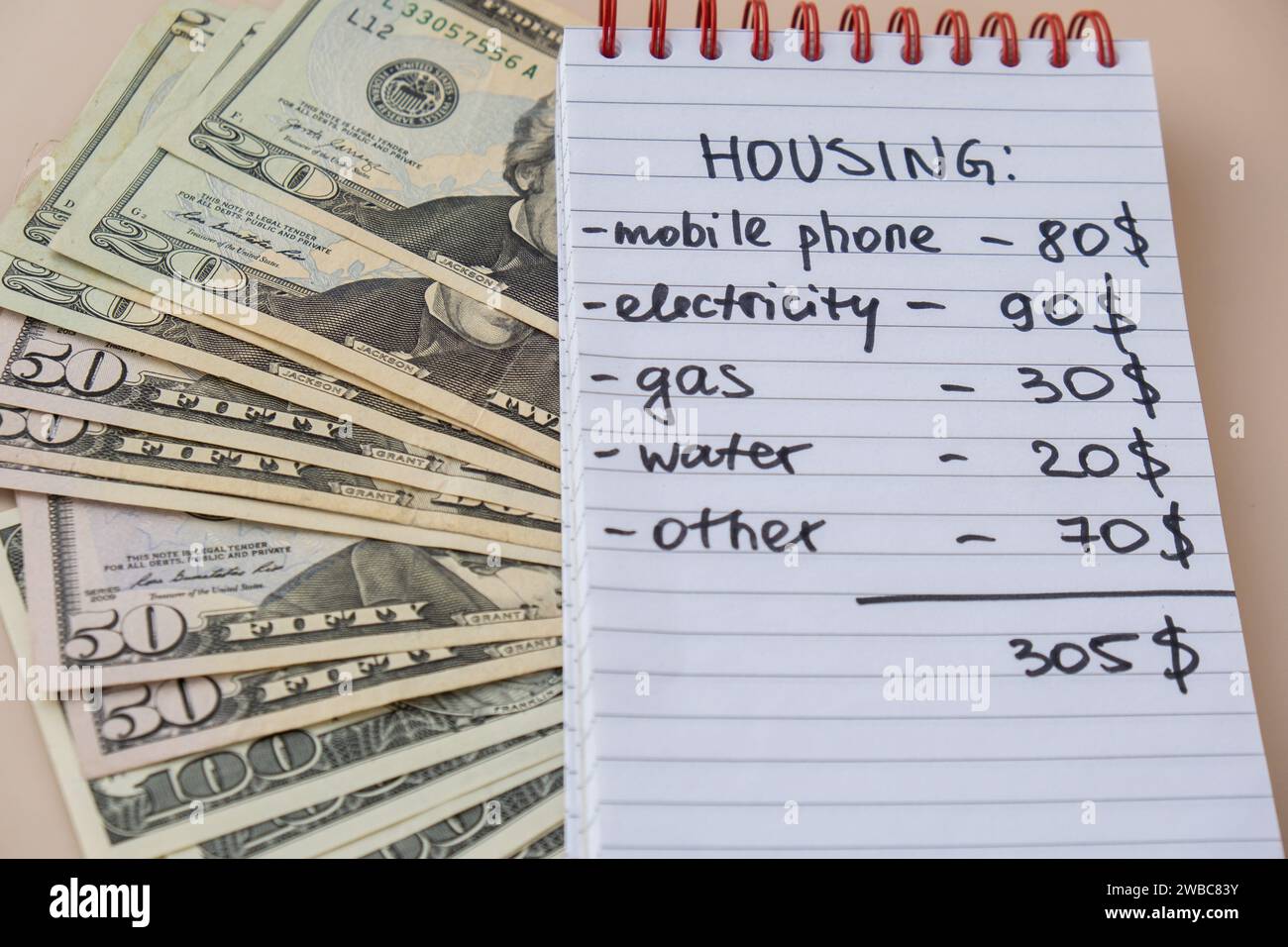 Dollar cash money with notebook handwritten housing expenses. Counting ...