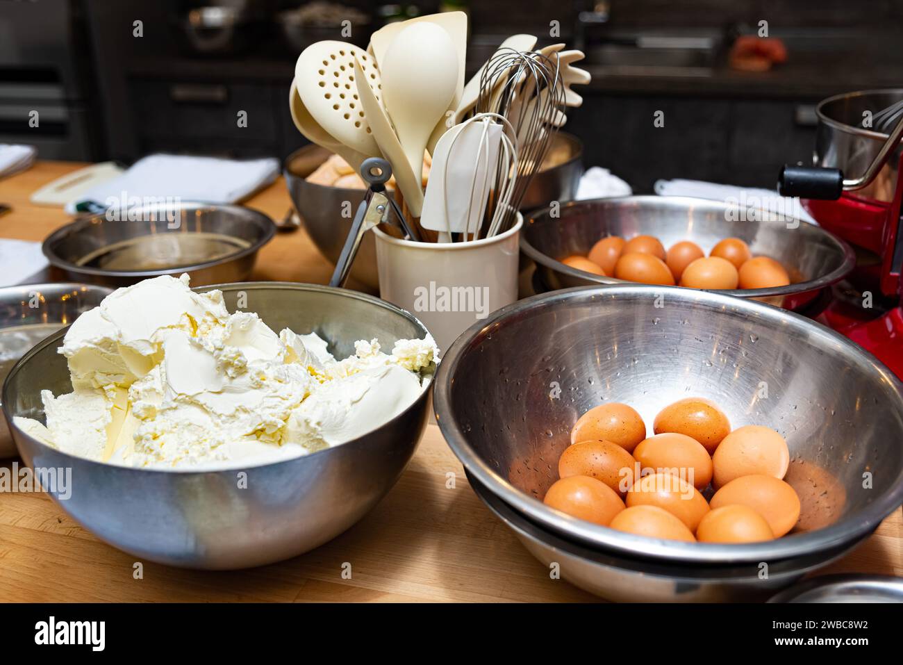 Busy kitchen counter with bowls of butter and eggs, kitchen utensils ...