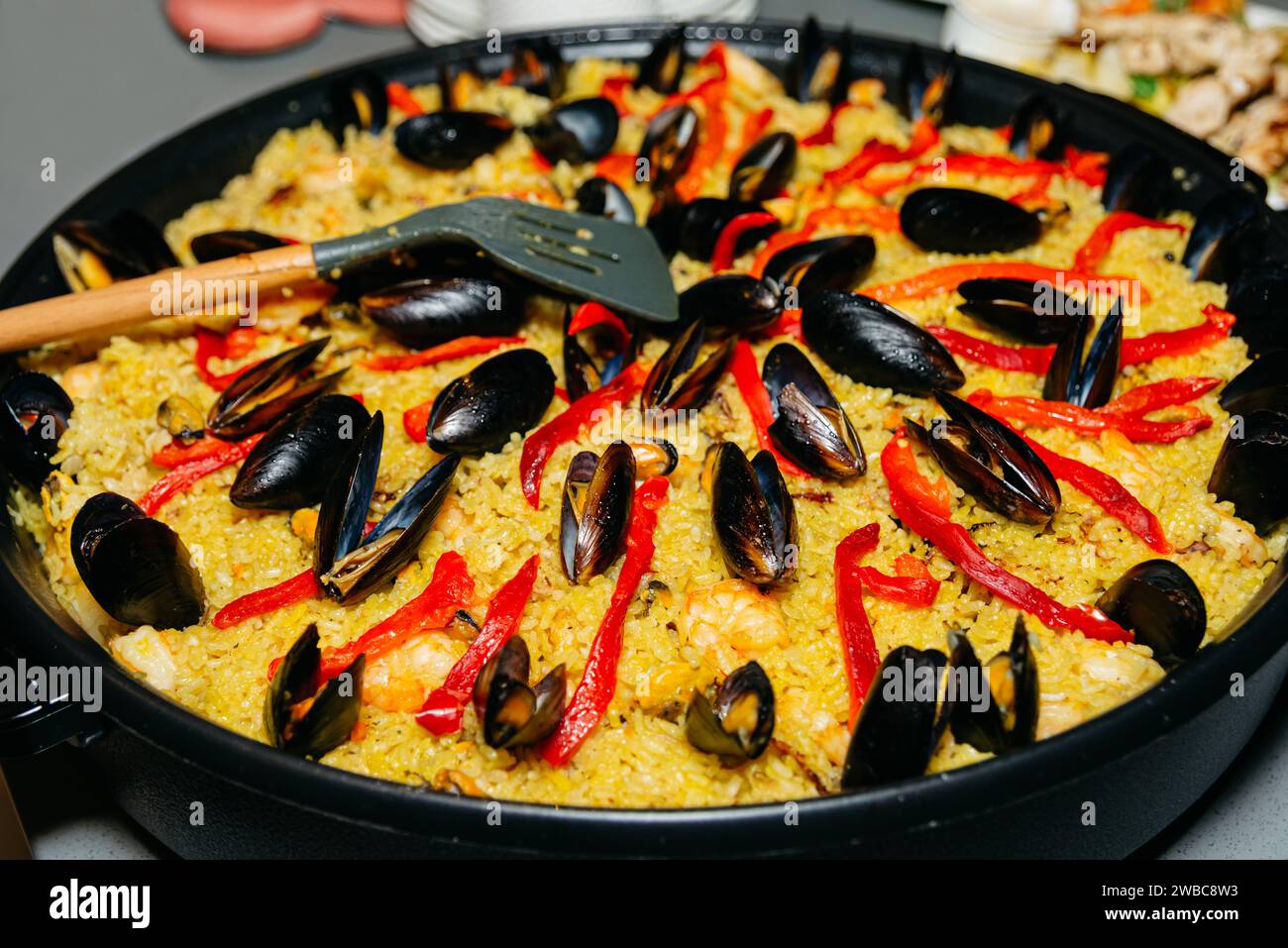 A traditional seafood paella featuring succulent mussels, red peppers ...