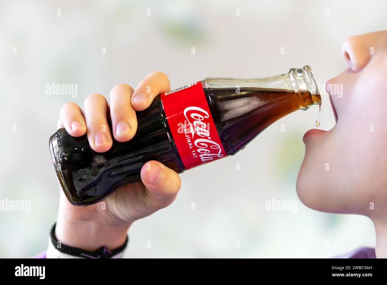 woman drinking coca cola on a blue background. August 27, 2023. Russia ...