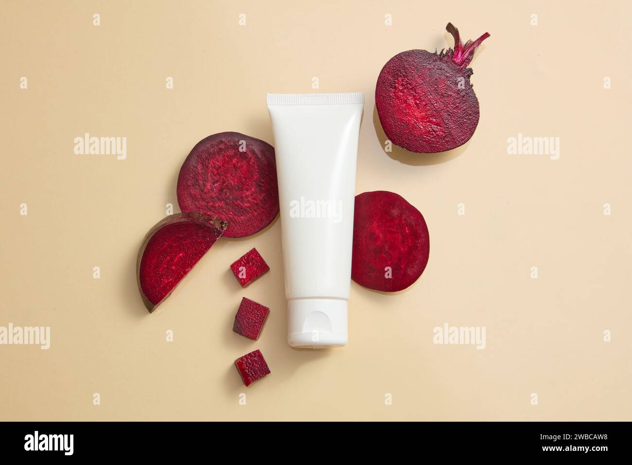 White plastic tube decorated with beet slice on beige background ...