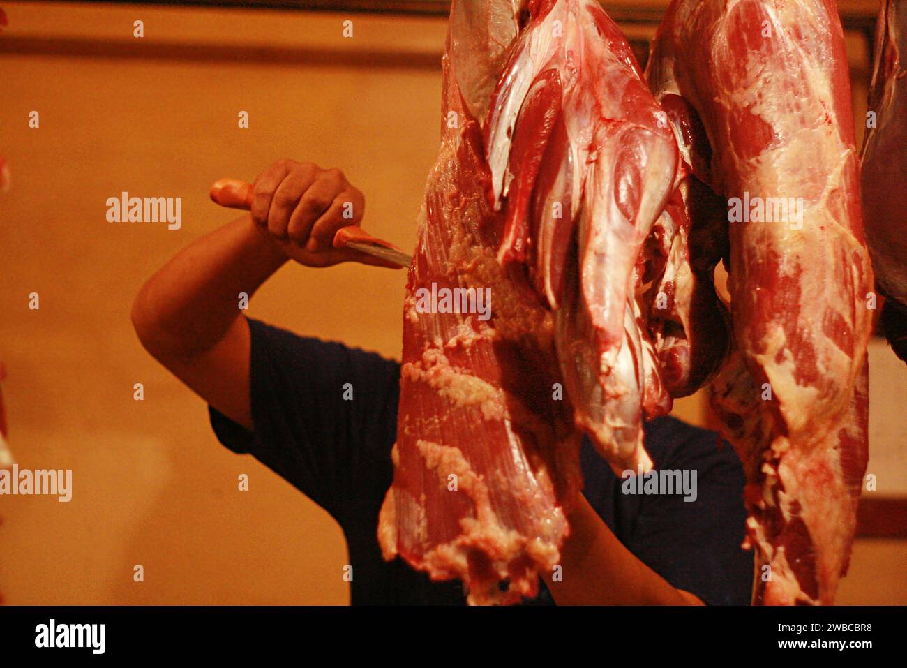 Butcher's hands cutting meat with knife in shop Stock Photo - Alamy