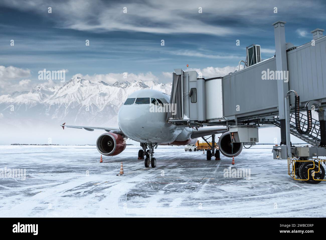 Modern passenger jetliner at the skybridge at winter airport apron on ...