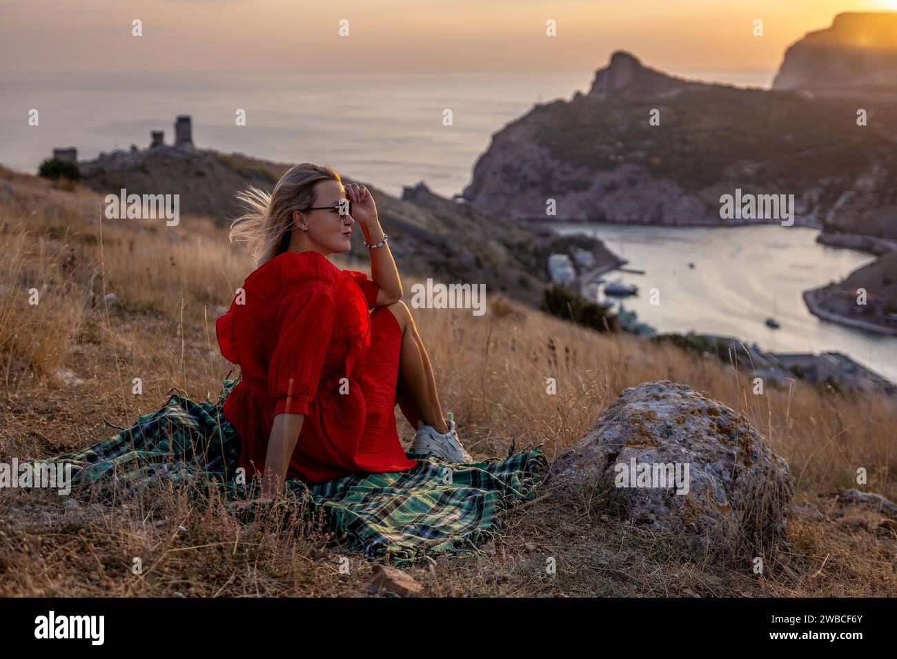 Woman sunset sea mountains. Happy woman siting with her back on the ...