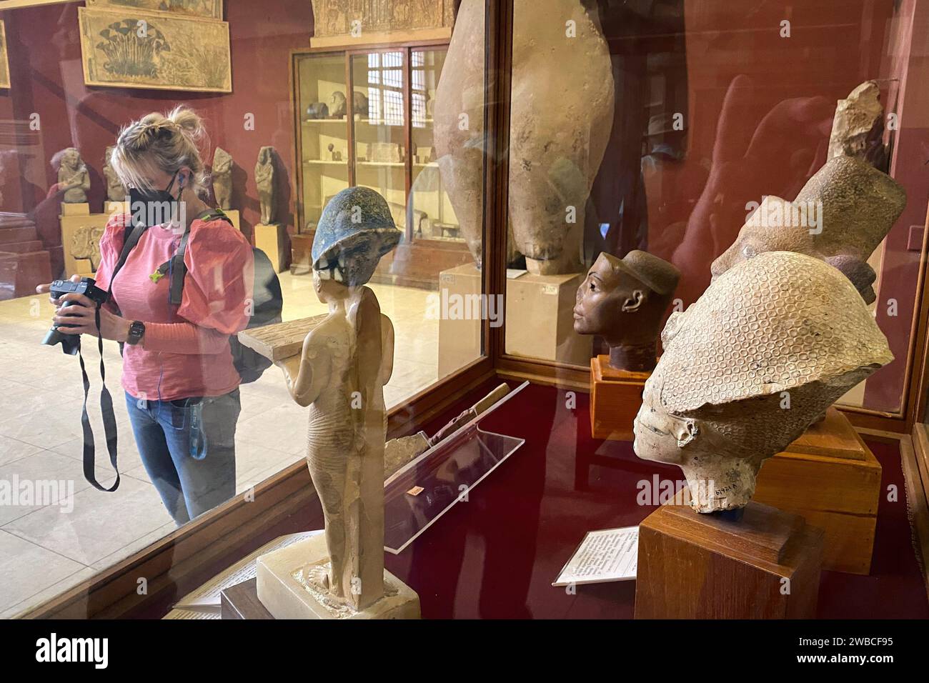 Cairo Governorate, Egypt. 8th Jan, 2022. Visitor takes a picture of ancient sculptures in the ...