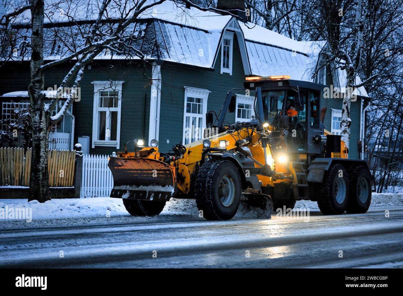 Yellow motor grader Vammas RG 286 removing snow from street early in ...