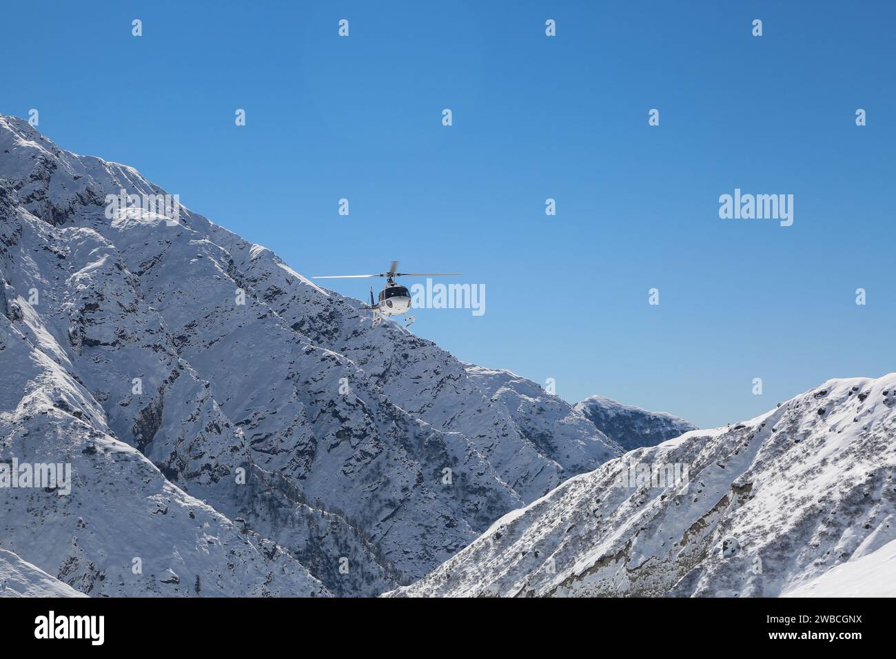 Helicopter flying in snow covered valley of Mountain in Himalaya. White ...
