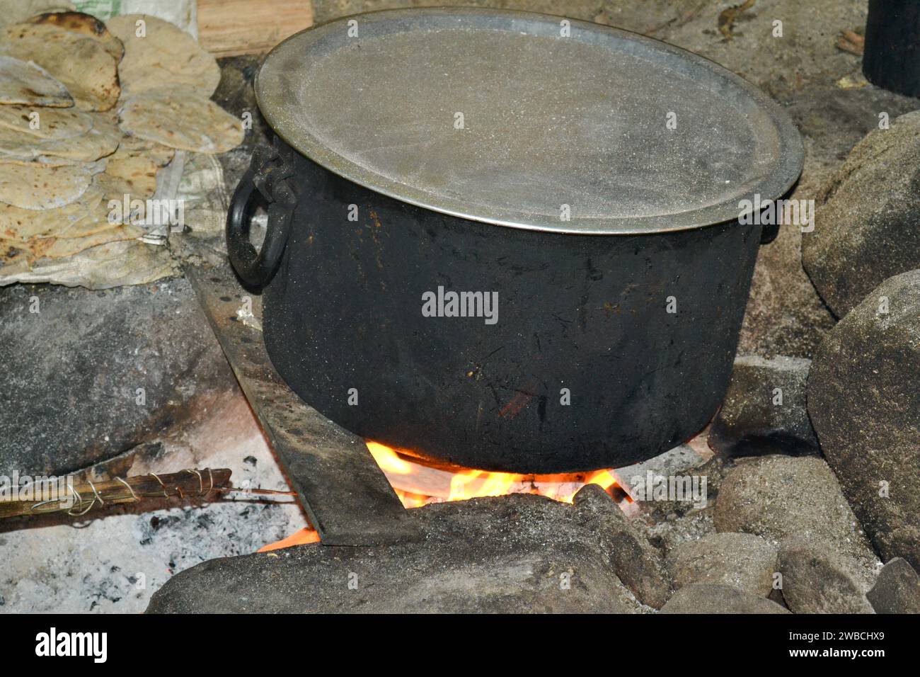 Traditional way of cooking in India. Preparing food in open fire in the ...