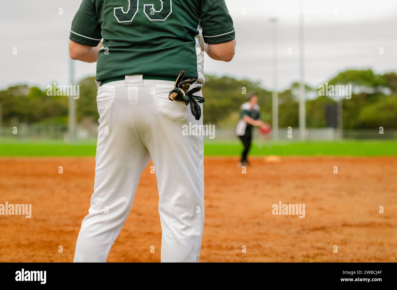 Baseball game, runner on the third base is watching the play and ...