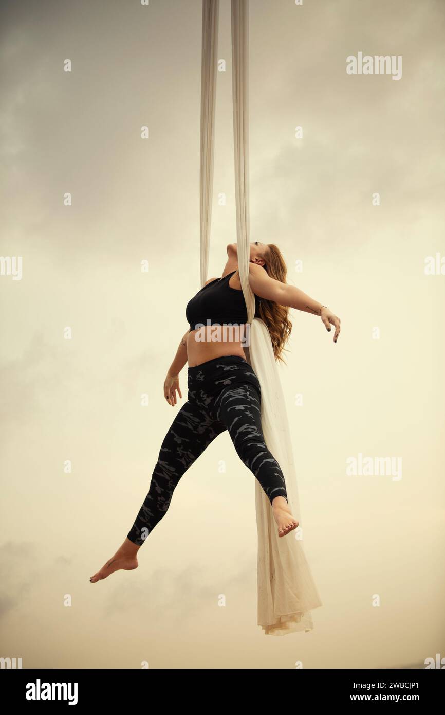 Female aerialist performing on aerial silk outdoors Stock Photo - Alamy