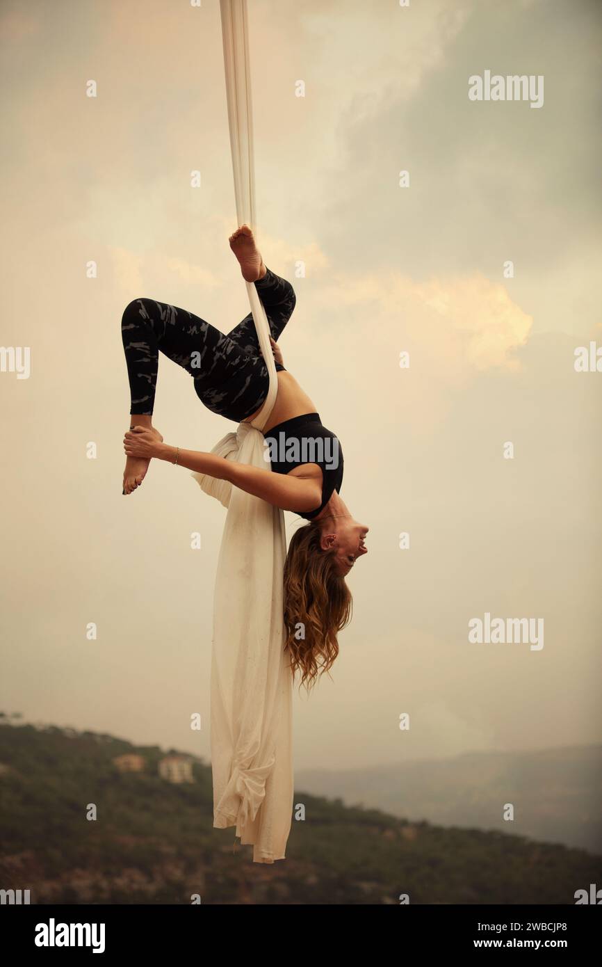 Female aerialist performing on aerial silk outdoors Stock Photo - Alamy