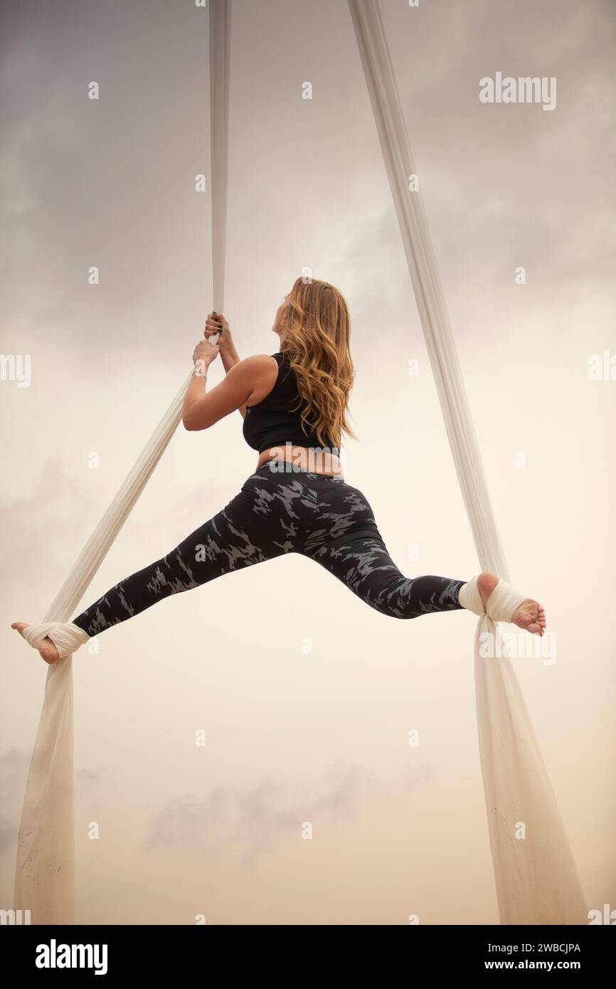 Female aerialist performing on aerial silk outdoors Stock Photo - Alamy