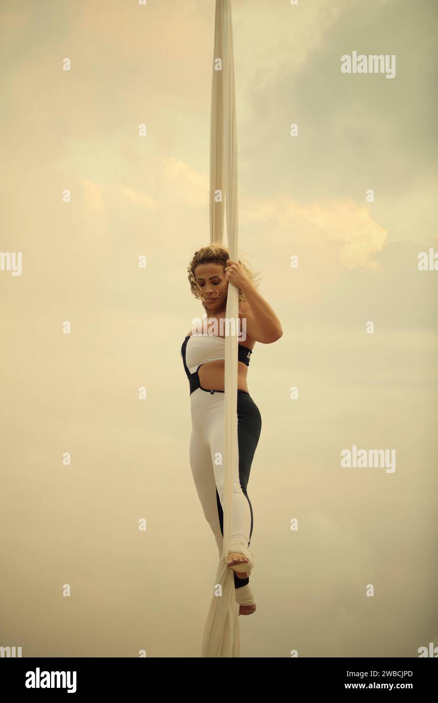 Female aerialist performing on aerial silk outdoors Stock Photo - Alamy