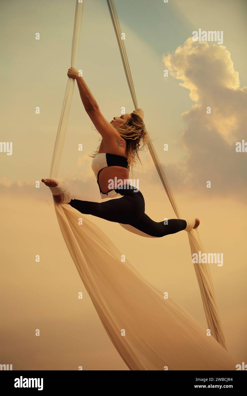 Female aerialist performing on aerial silk outdoors Stock Photo - Alamy