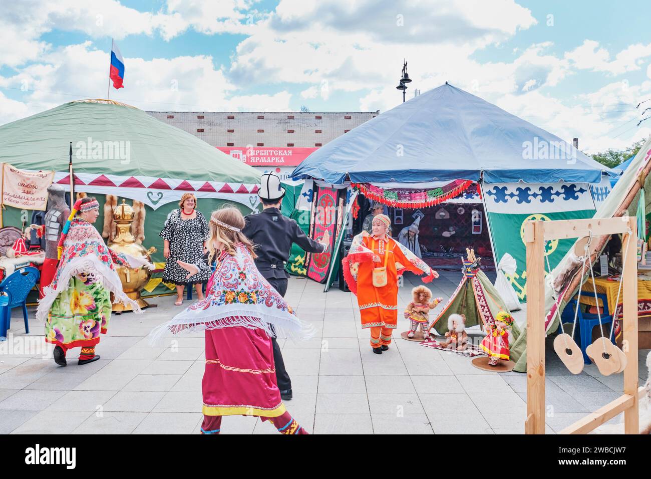 People in festive clothes of ethnic groups of Urals dancing at ...